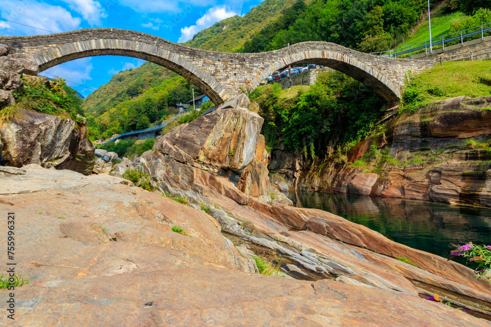 Ancient double arch stone Roman bridge (Ponte dei Salti) over the clear ...