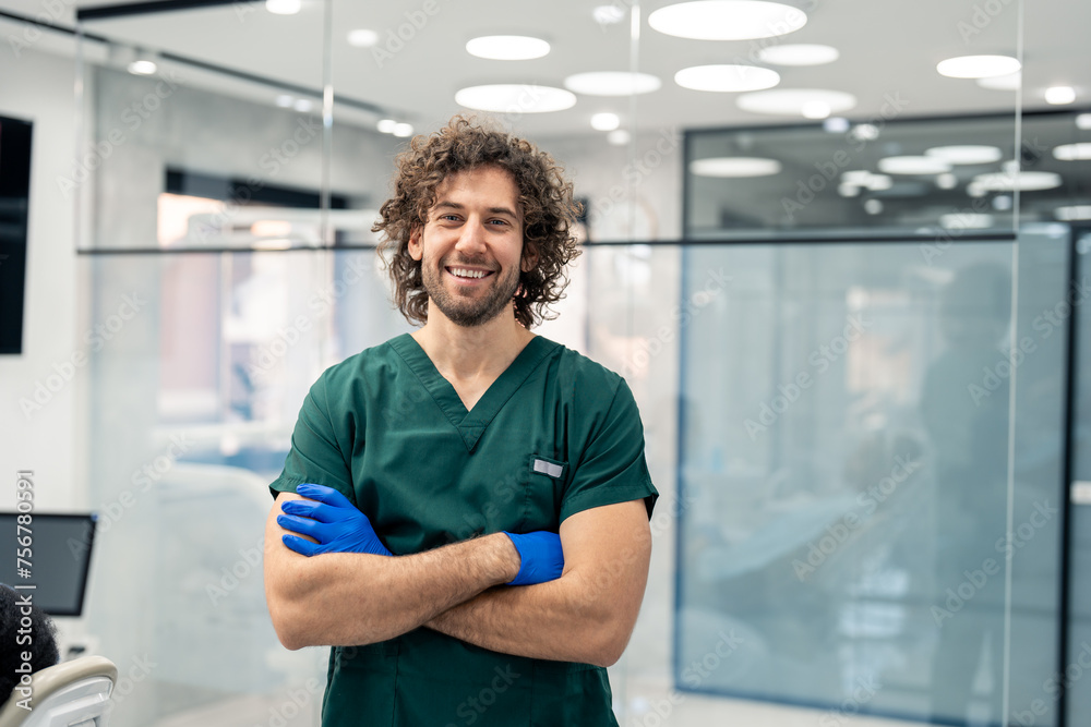 Proud young dental surgeon wearing green medical uniform posing for ...