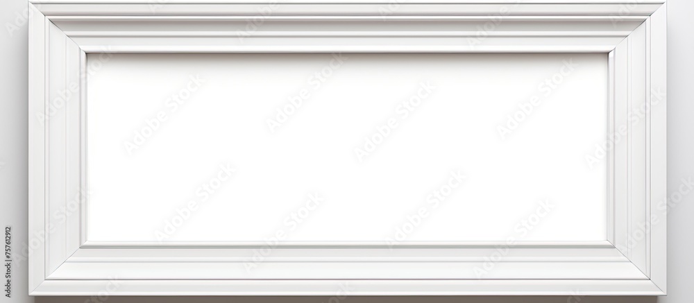 A rectangular white picture frame hangs on a white wall, creating a ...