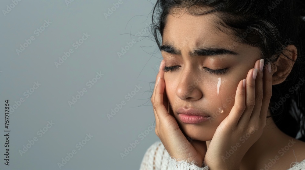 A teenage Indian girl, traumatized and with tears streaming down her ...