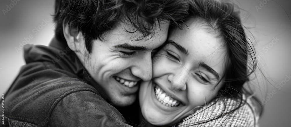 In the black and white photo, a man and a woman are embracing with ...