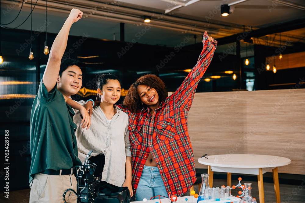 Students in classroom raise hands joyfully marking success of their ...