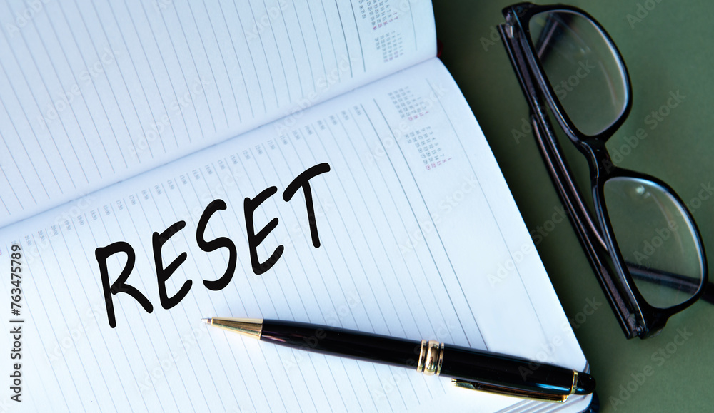 RESET - word in notebook on green background with glasses and pen Stock ...