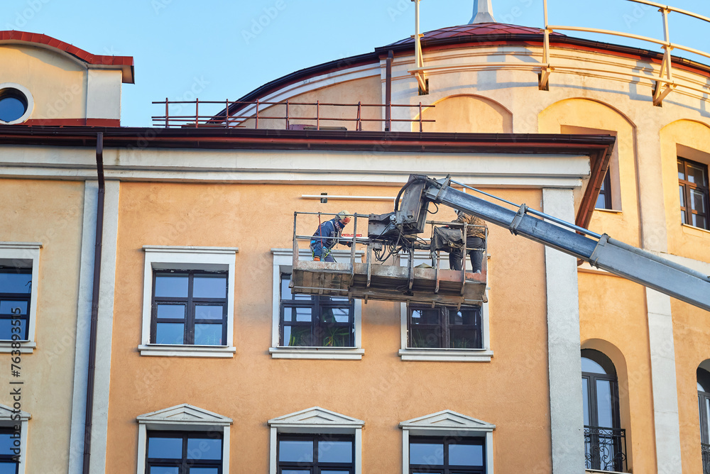 Photo Stock Workers using cradle crane to install an advertisement ...