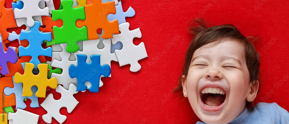 Funny child crying or laughing with colorful jigsaw puzzle pieces ...