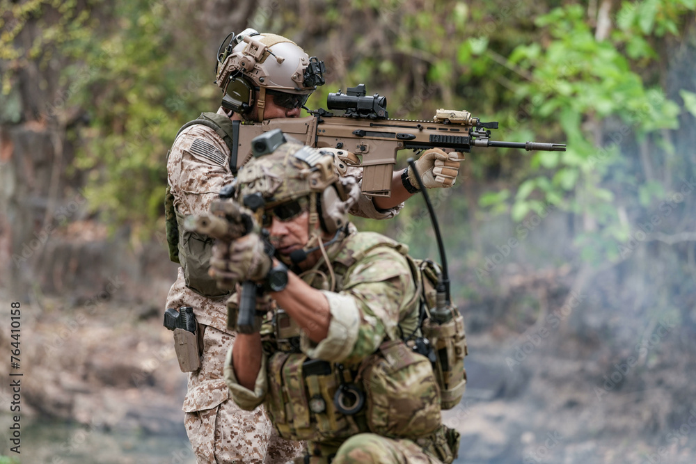 Soldiers in tactical gear aiming guns during a military exercise ...