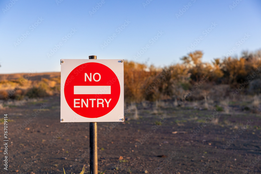 No entry sign with a desert landscape out of focus in the background ...