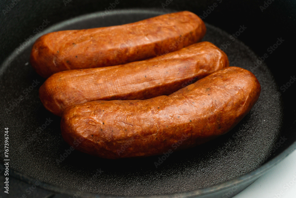 Frying freshly taken out precook smoked sausages from the chiller using ...