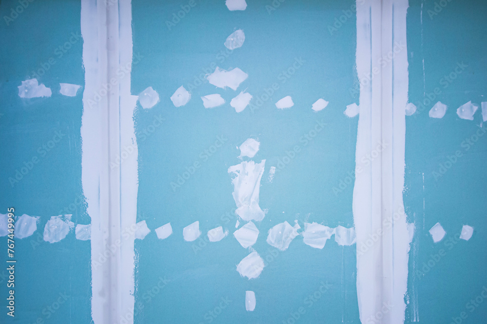 texture of drywall with evenly twisted screws and putty joints in a new ...