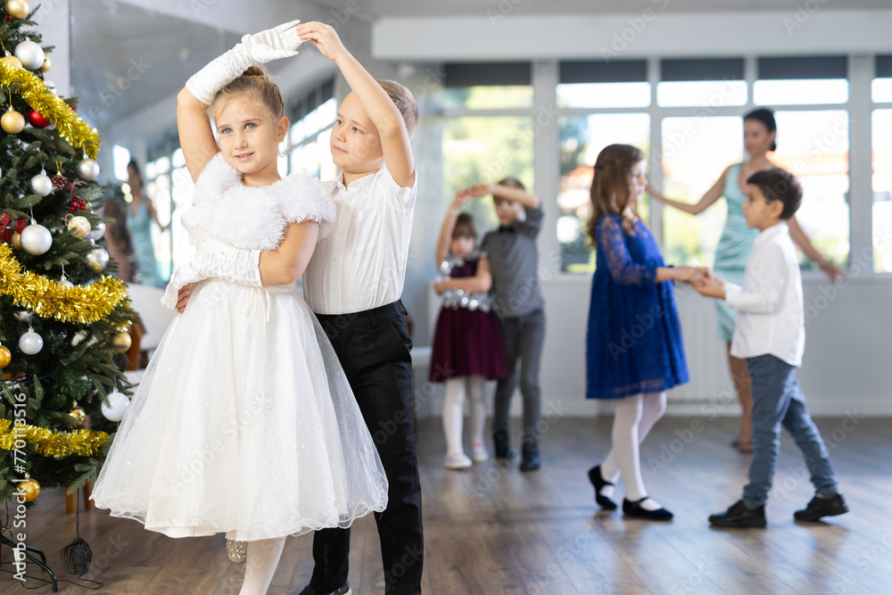 Couple of smiling tweens, boy and girl in festive clothing performing ...