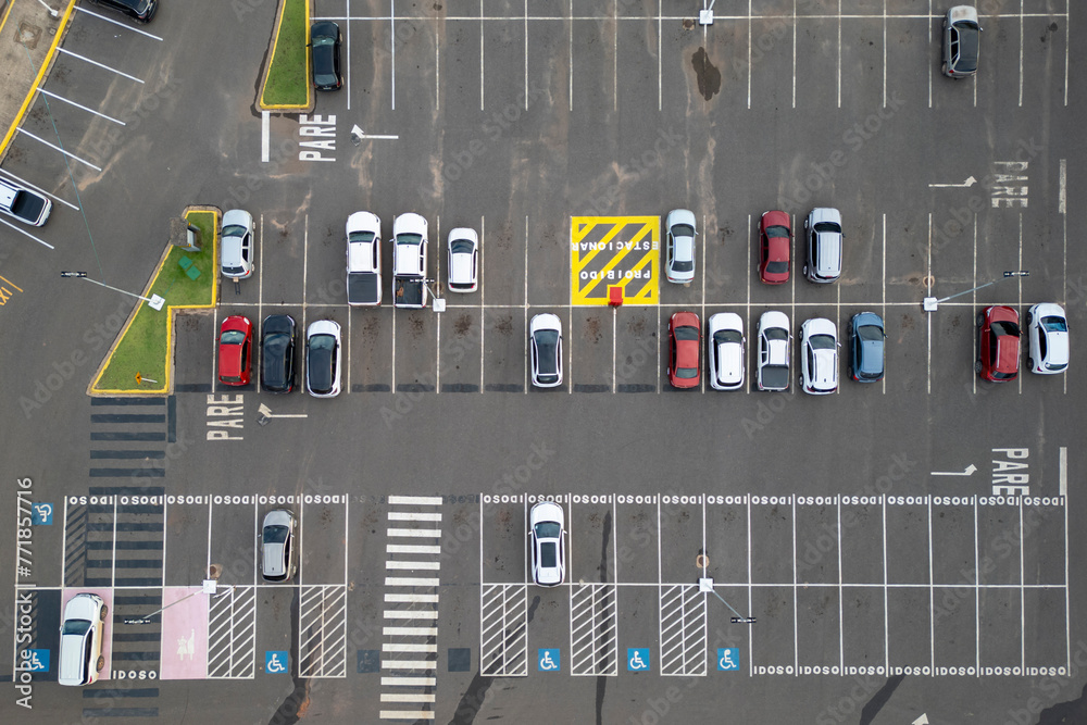 Aerial view of expansive parking lot with cars parked, empty spaces ...