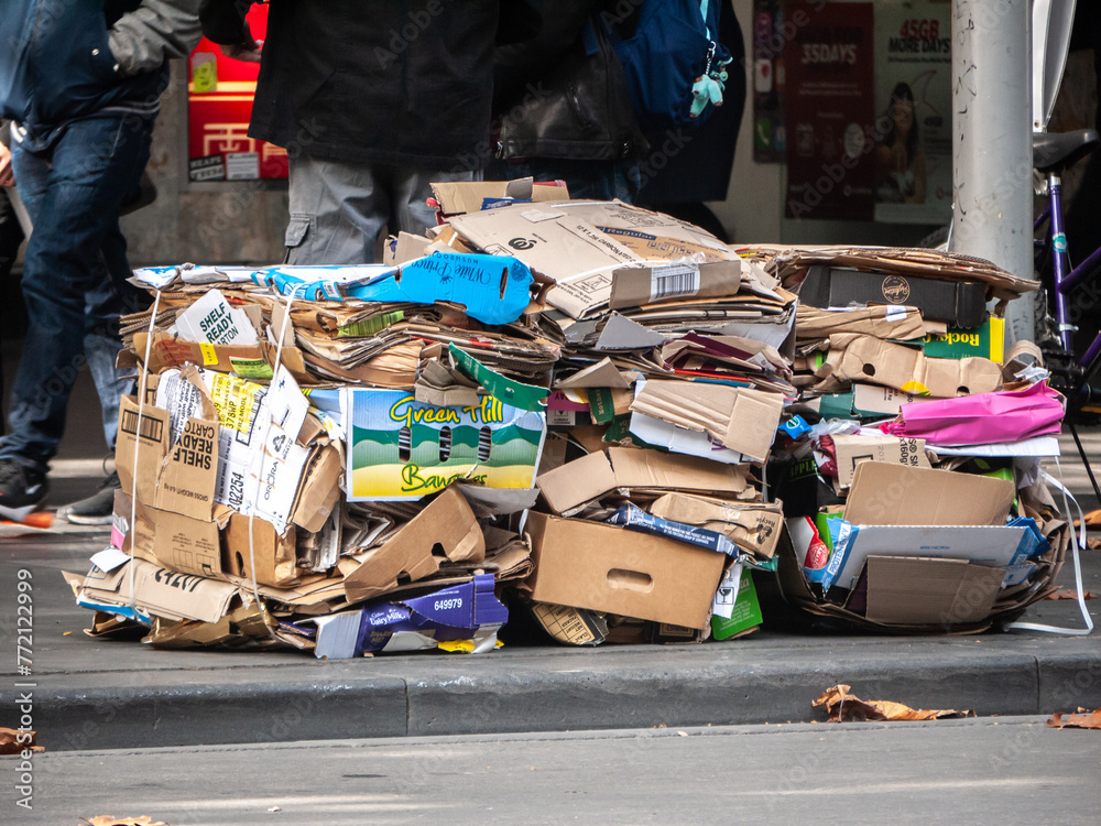 A bundle of cardboard wrapped and tied, placed at the road curb ...