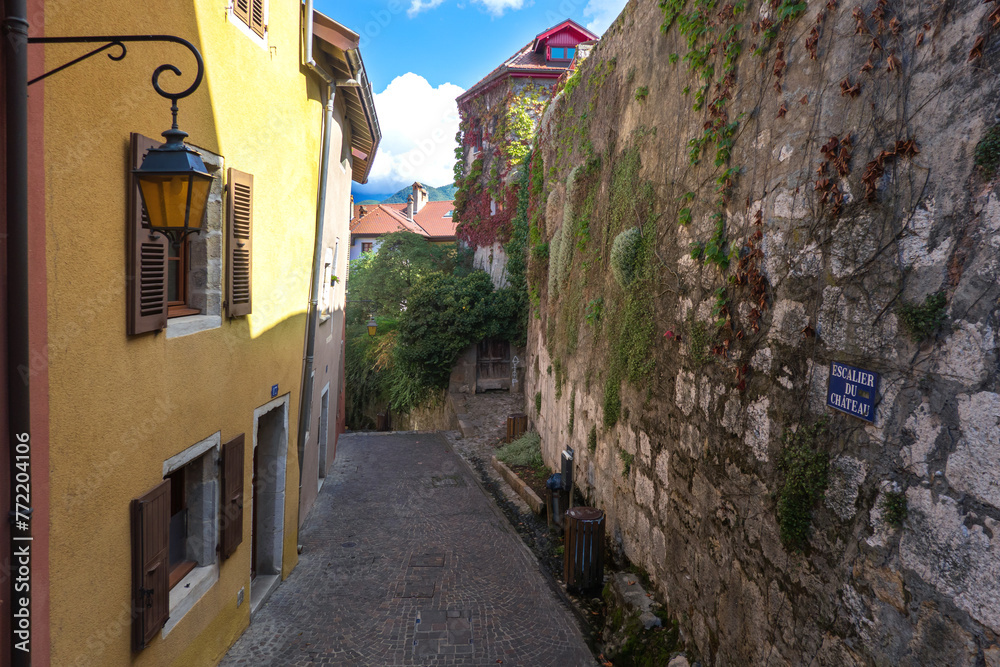 Descent from Annecy Castle along the fortress wall, overgrown with ...