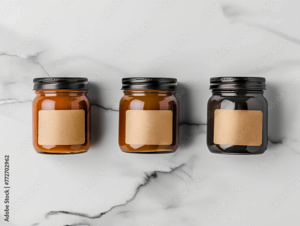Three amber glass cosmetic jars with blank labels on a marble ...