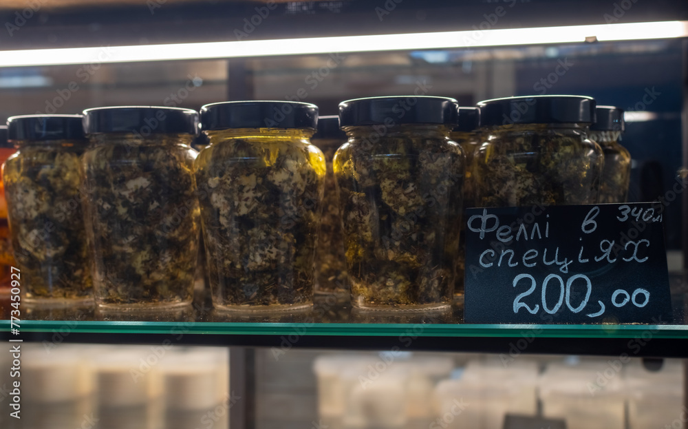 Felli cheese balls in spices in glass jars close-up on store shelf at ...