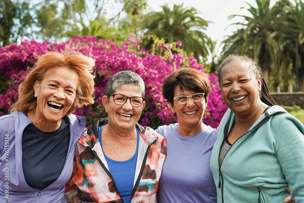 Group of happy diverse senior women hugging each other at city park ...