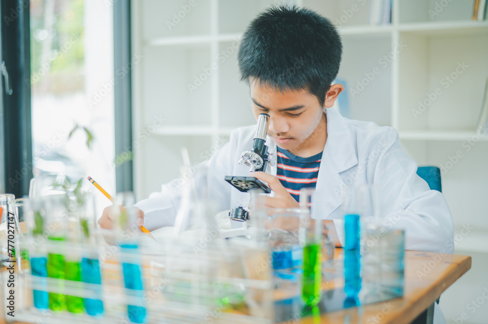 Asian male science students looking through a microscope and tests of ...