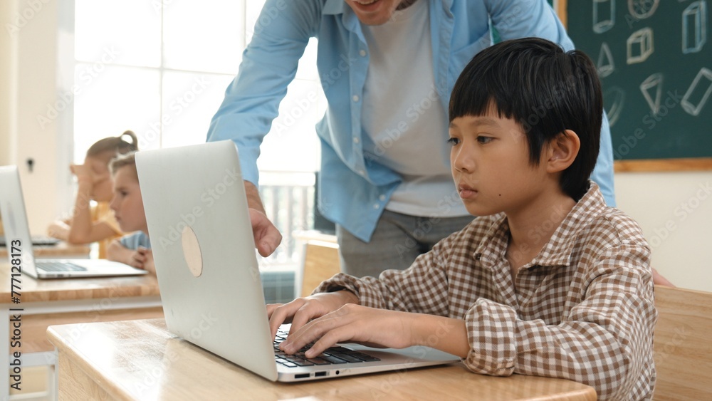 Photo Stock Caucasian teacher helping asian student coding engineering prompt while diverse ...