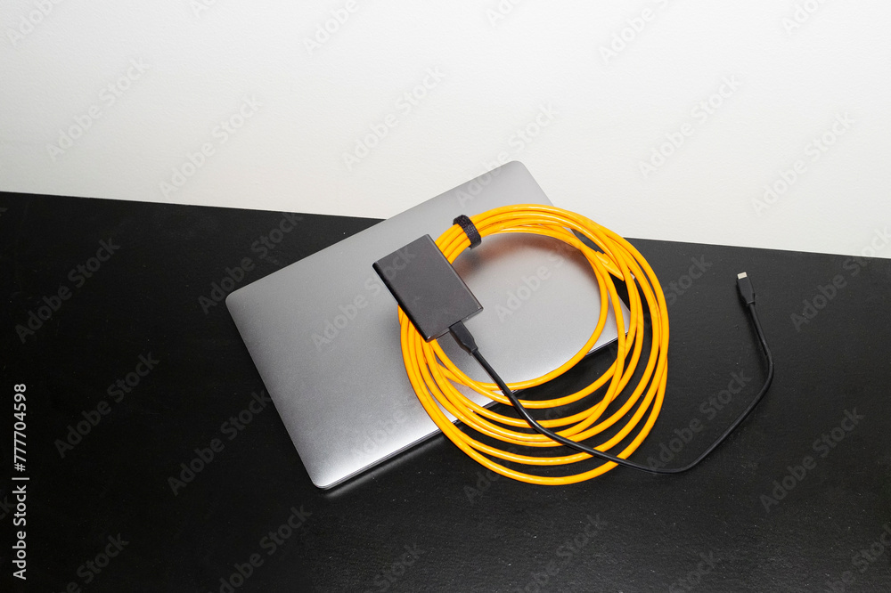 Silver laptop and orange wire with hard direct flashlight Stock Photo ...