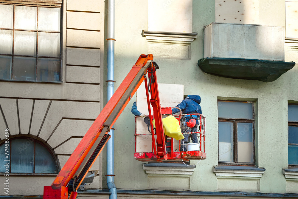 Photo Stock Construction workers attaching plywood for window ...
