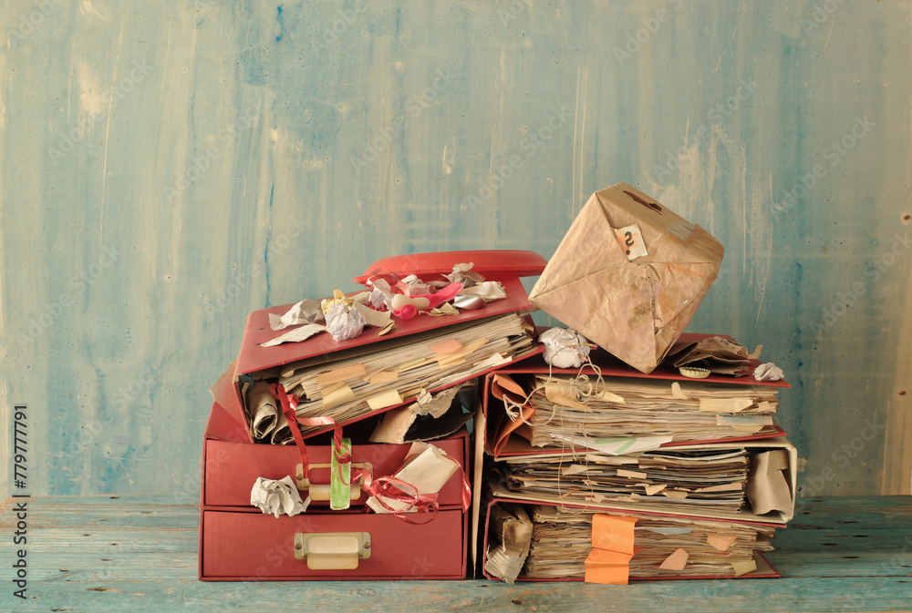 messy file folders and storage boxes in a cluttered office ,red tape ...
