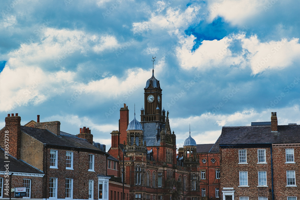 Dramatic clouds loom over a historic town center, featuring a prominent ...