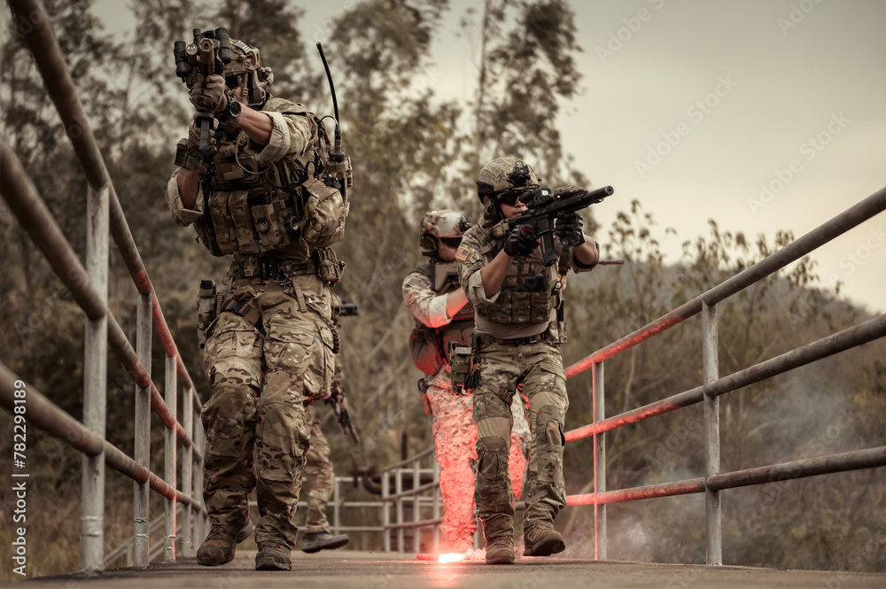 Soldiers in camouflage uniforms aiming with their rifles.ready to fire ...