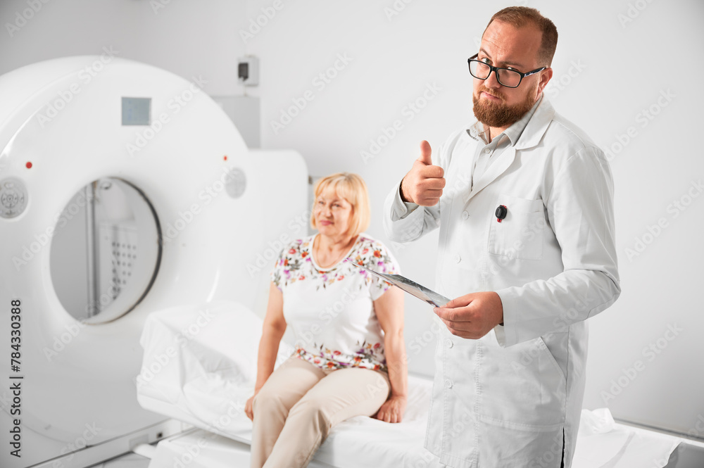 Medical computed tomography or MRI scanner. Doctor holding results of ...