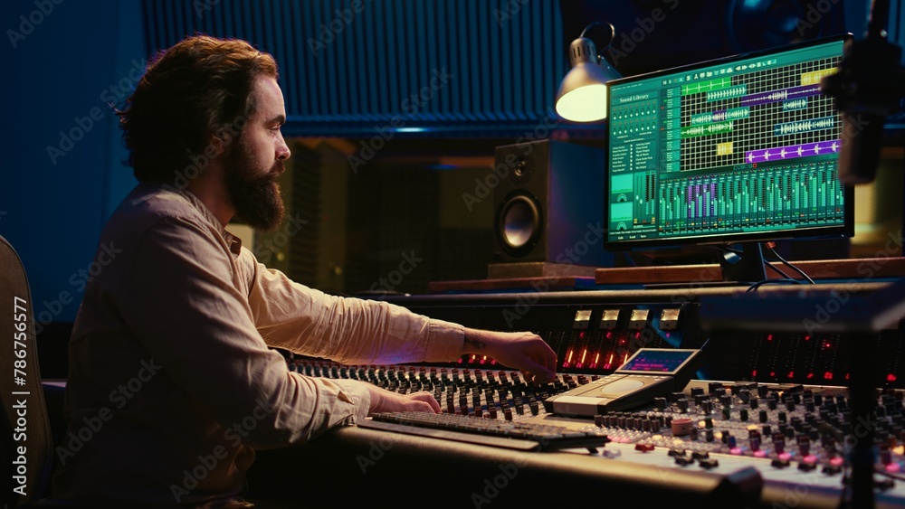 Professional tracking engineer editing music by adding sound effects in ...