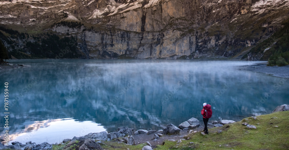 Sporty girl looking into reflection of mountains in lake. Lake ...