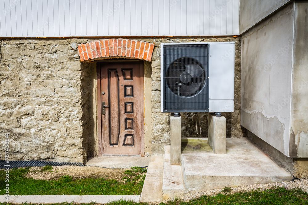 Air source heat pump installed outside of old renovated house, green ...