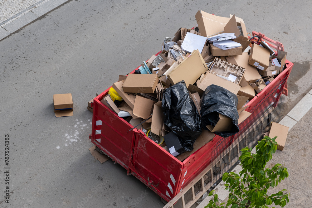 A waste container overflowed A steel industrial with rubbish on the ...
