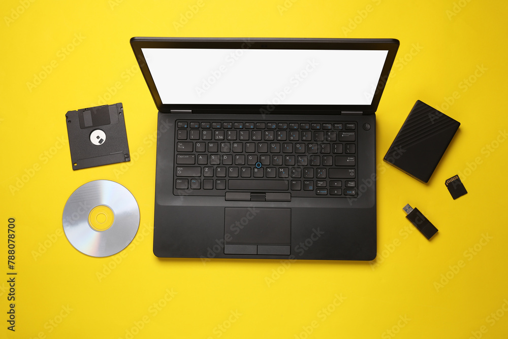 Evolution of storage media. Laptop with CD disk, sd card, floppy disk ...