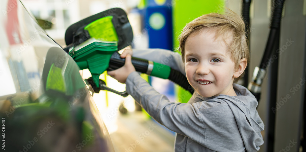 Cute little blond boy holding pump nozzle. Small kid helping father to ...