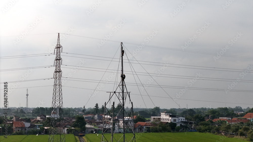 construction of electric pylons. people climbing power towers to erect ...
