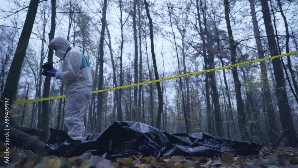 Forensic experts scrutinize the crime scene, with a deceased person in ...