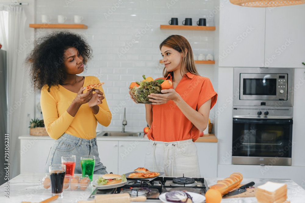 Two women choosing between vegetable and sausage, organic food vs gmo ...