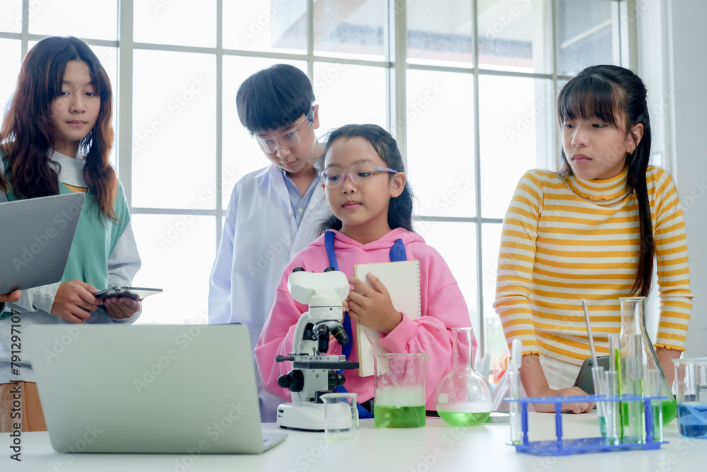 Students' learning in science. Young learners with safety goggles watch ...
