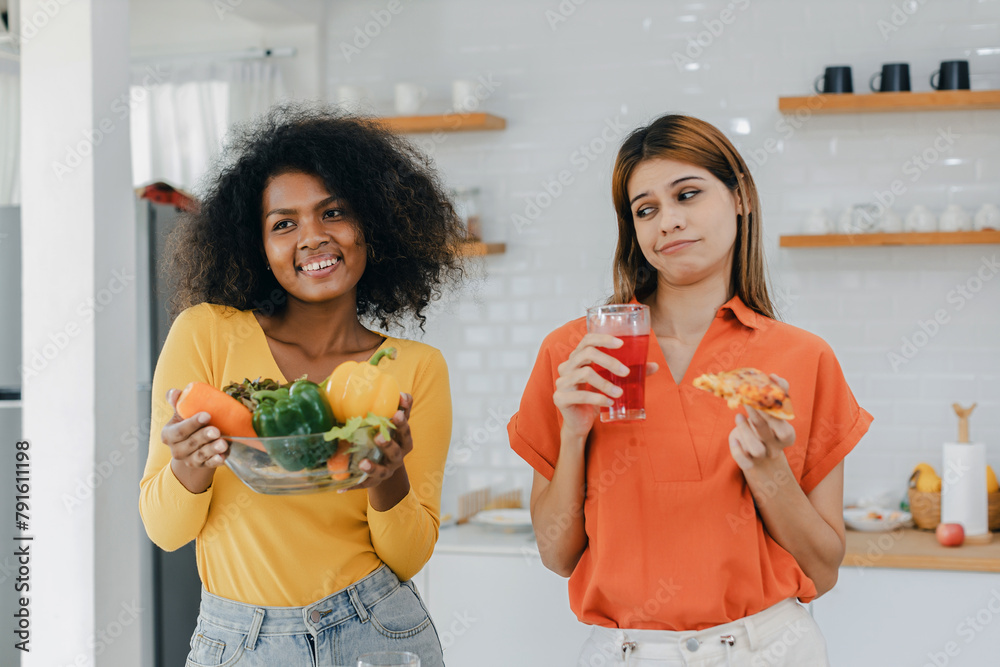 Two women choosing between vegetable and sausage, organic food vs gmo ...
