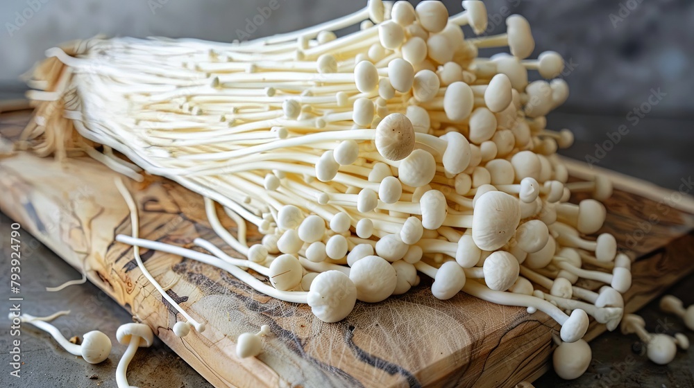 Heap of enoki mushrooms piled on a cutting board, known for their ...