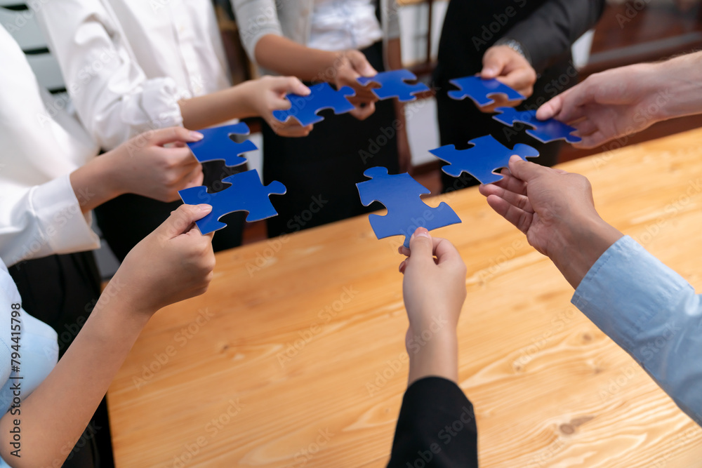 Multiethnic business people holding jigsaw pieces and merge them ...