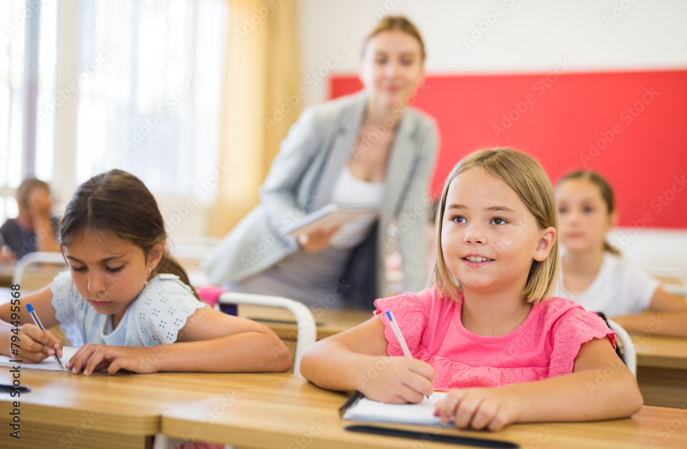 Smiling diligent elementary school student preteen girl studying with ...
