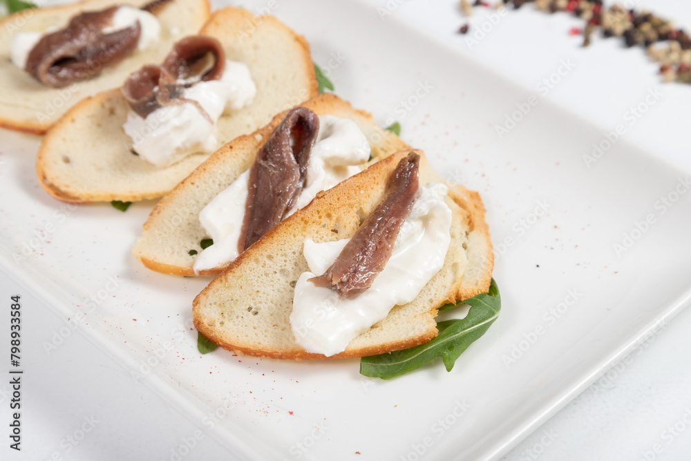 Tasty slices of bread with butter and salted anchovy fillets ...