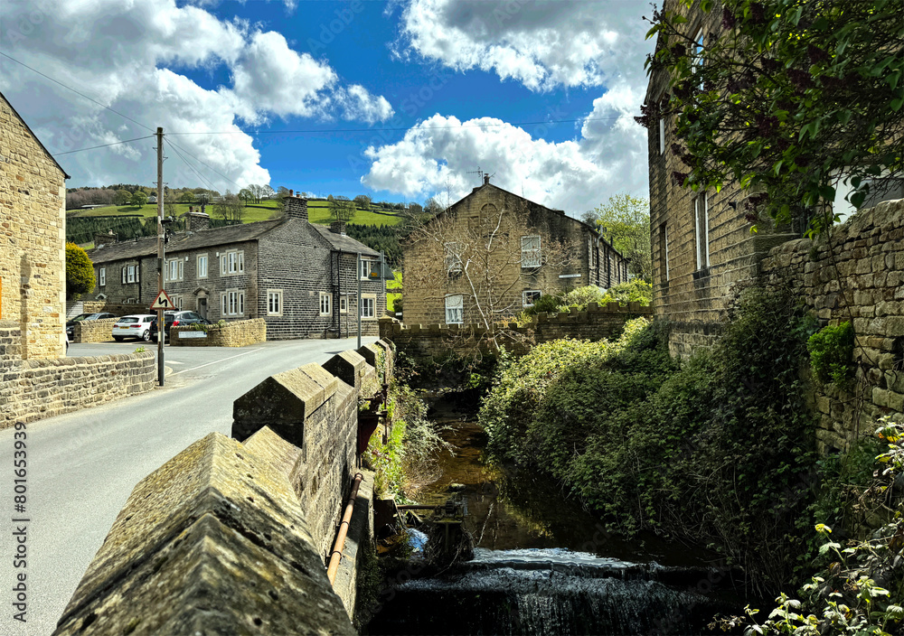 Holme Beck flows beside a stone wall and beneath a charming road, with ...