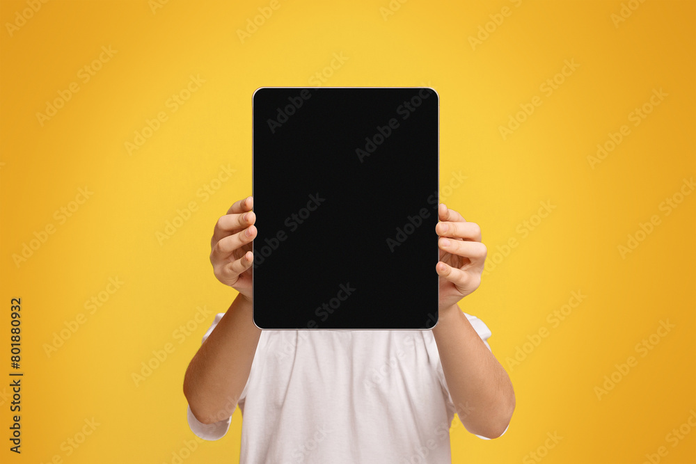 Tablet face. Little boy hiding his face behind portable computer device ...