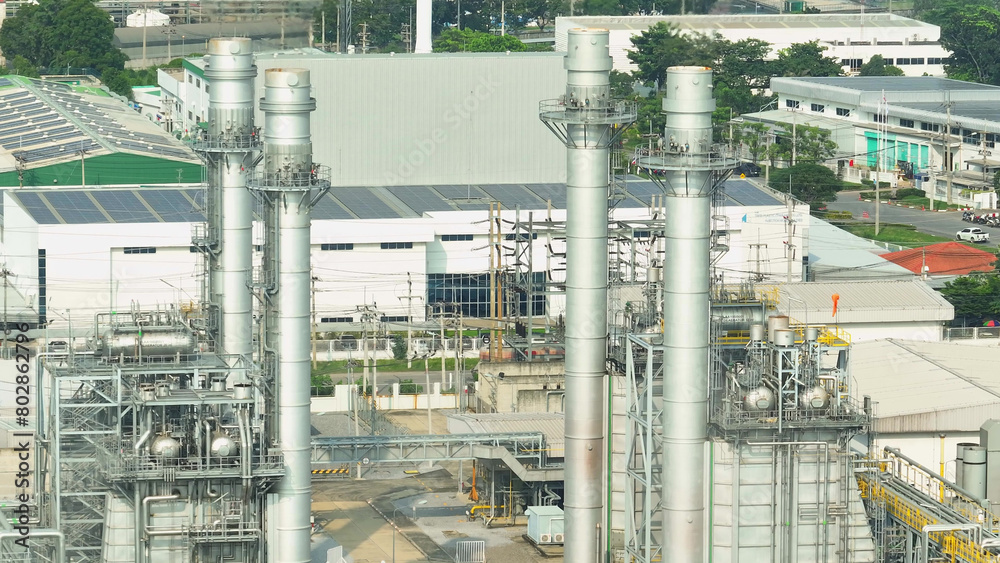 Aerial view of a massive power plant, its towering stacks emitting ...