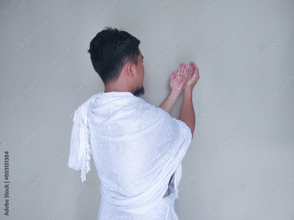 Muslim man praying while standing in white traditional clothes open his ...
