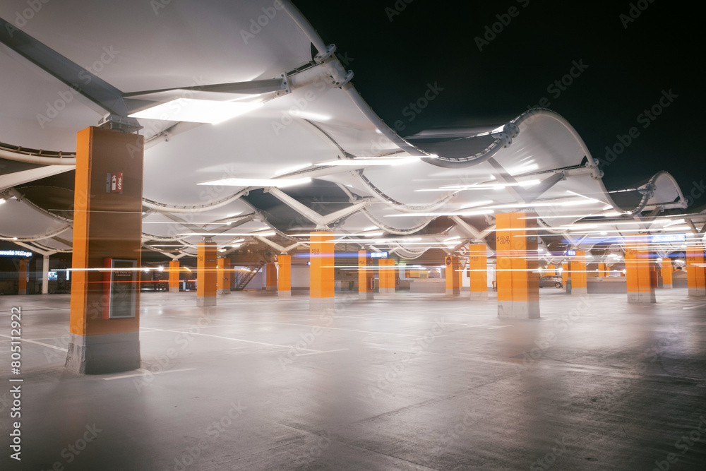 Empty indoor parking lot at night showcasing bright lighting, colorful ...