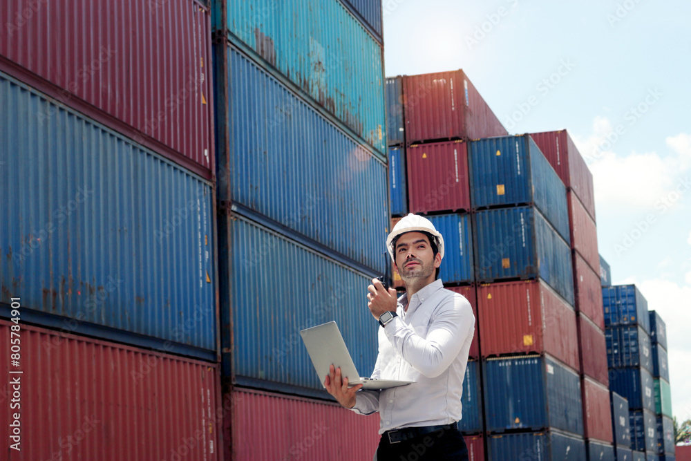 Handsome businessman wearing safety helmet, using walkie talkie and ...