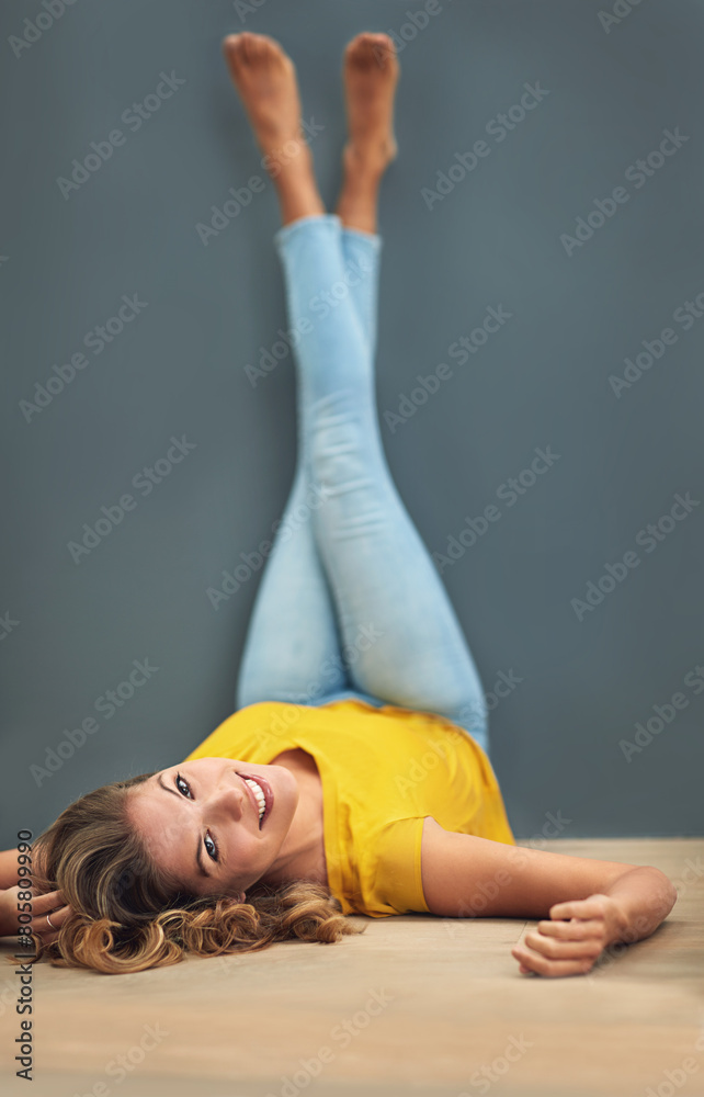 Woman, floor and portrait by studio background with legs up, relax ...